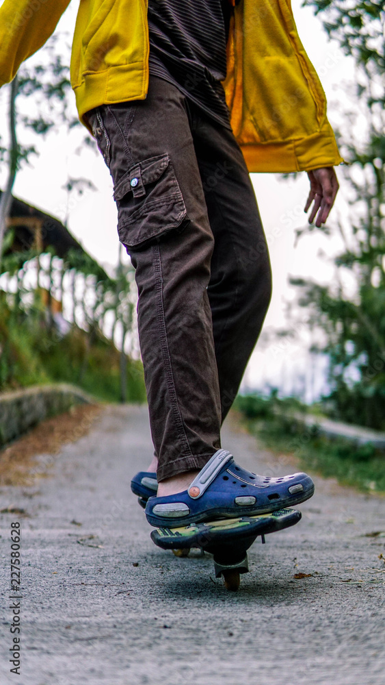 Man Riding a Waveboard, Type of Skateboard in the road, Wearing Yellow ...