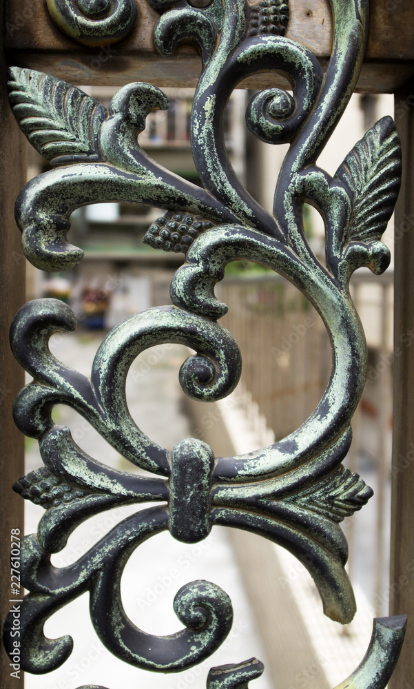Wrought iron railing. Shapes of leaf and elegant curves. Dark green ...