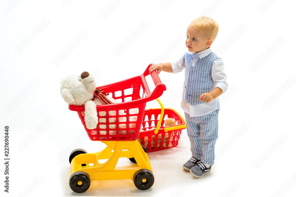 little boy child in toy shop. little boy go shopping with full cart ...