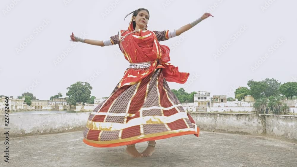 An attractive girl in a traditional attire dancing besides a beautiful ...