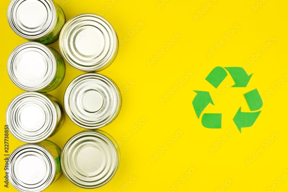 Green recycle reuse sign symbol with metal aluminium cans on yellow ...