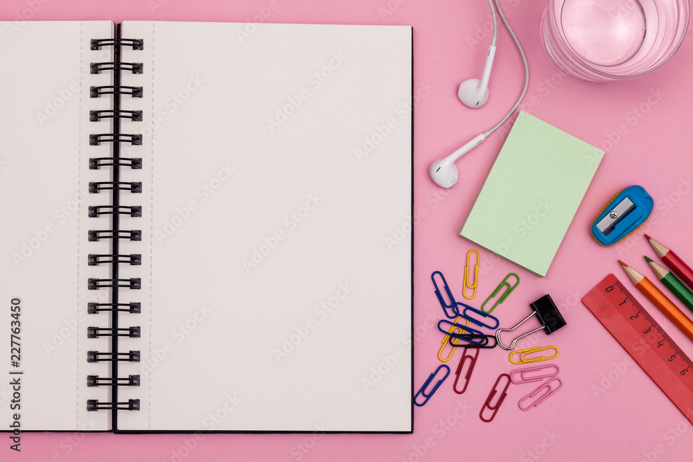 Open school notebook for your text over colorful supplies on pink ...