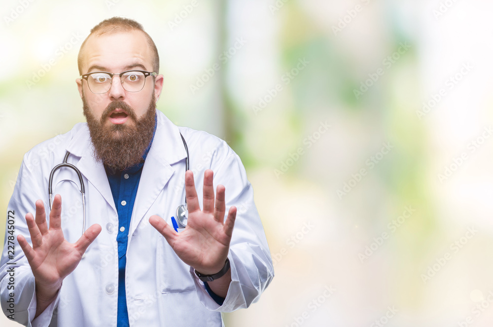 Young caucasian doctor man wearing medical white coat over isolated ...