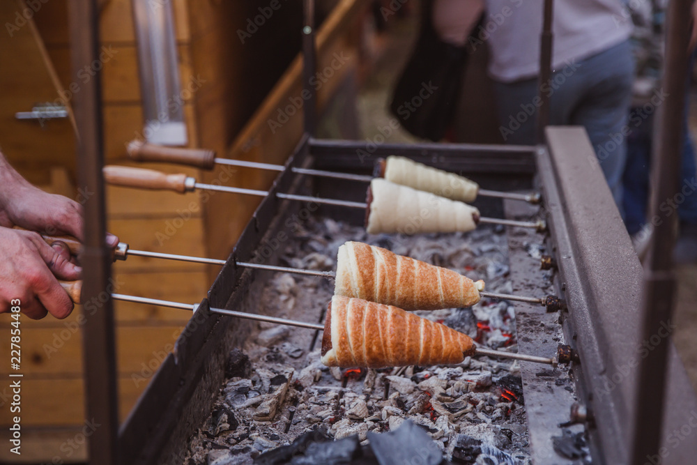 The baking of Kurtoskalacs, the traditional hungarian spit cake, in a ...
