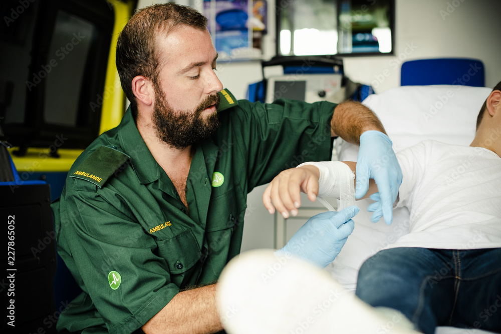 Paramedic giving a first aid to a young boy in an ambulance Stock Photo ...