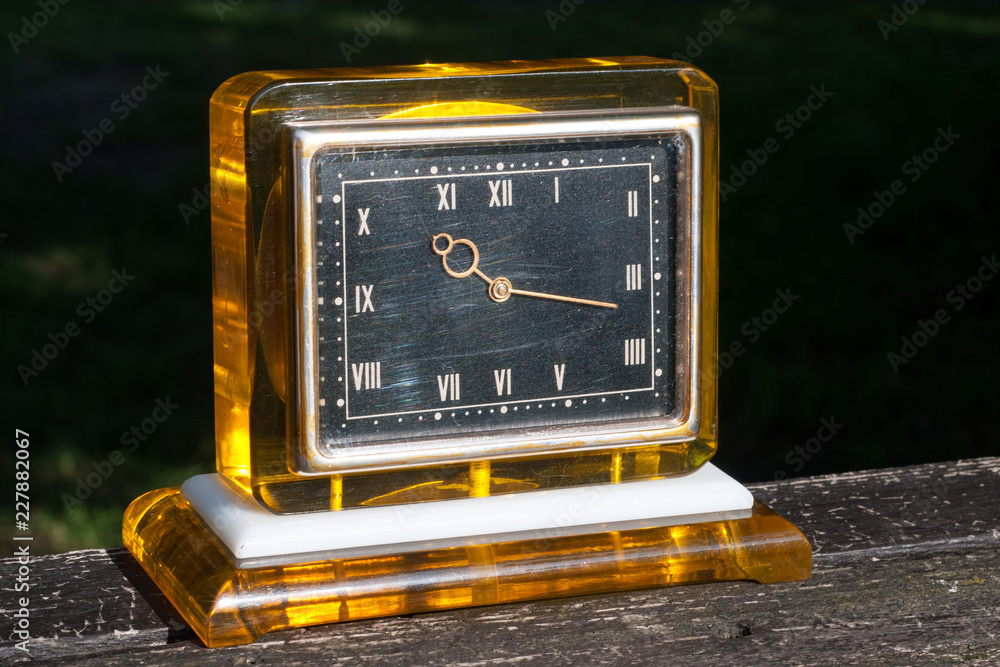 Old square amber desktop clock with a black dial, gold hands and a ...