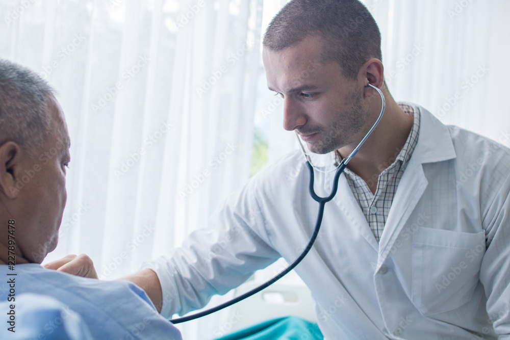 doctor use stethoscope for heart measuring with old patient man on bed in hospital foto de Stock ...