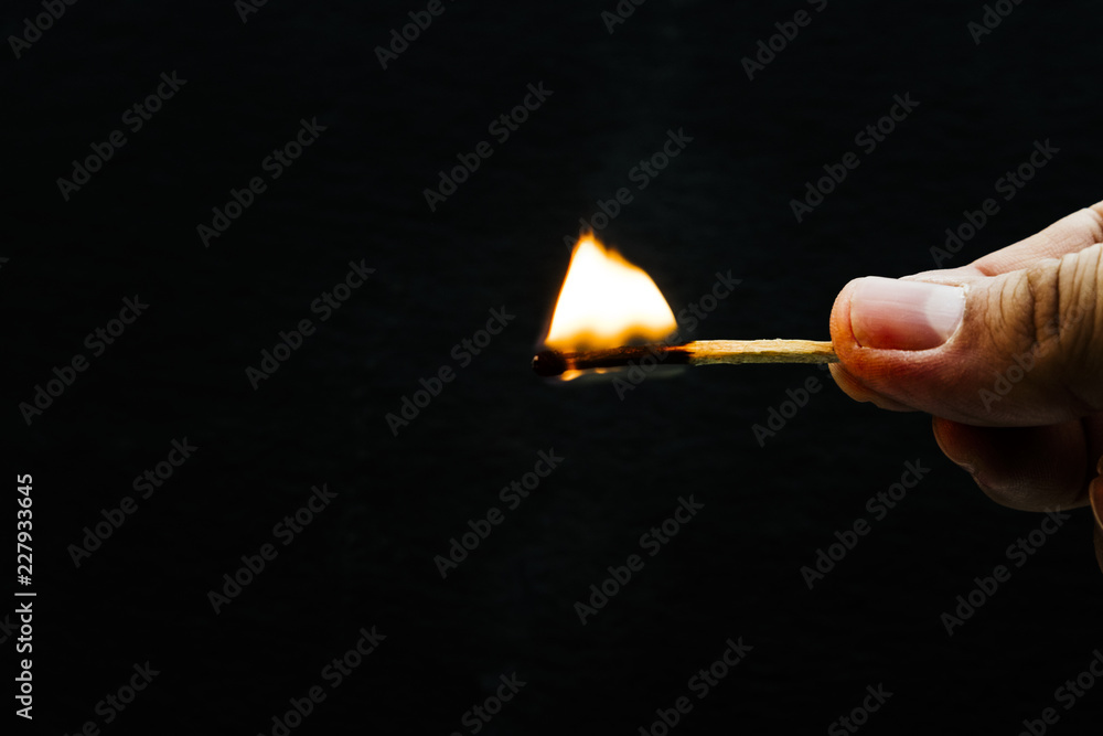 hand holding lighted match with black background Stock Photo | Adobe Stock