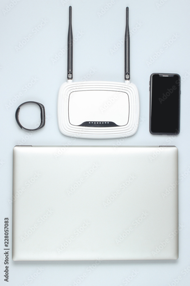 Laptop, Wi-Fi router with antennas, smart phone, smart watch on a gray ...