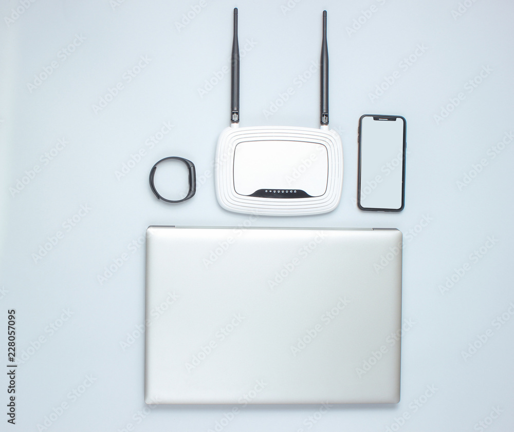 Laptop, Wi-Fi router with antennas, smart phone, smart watch on a gray ...
