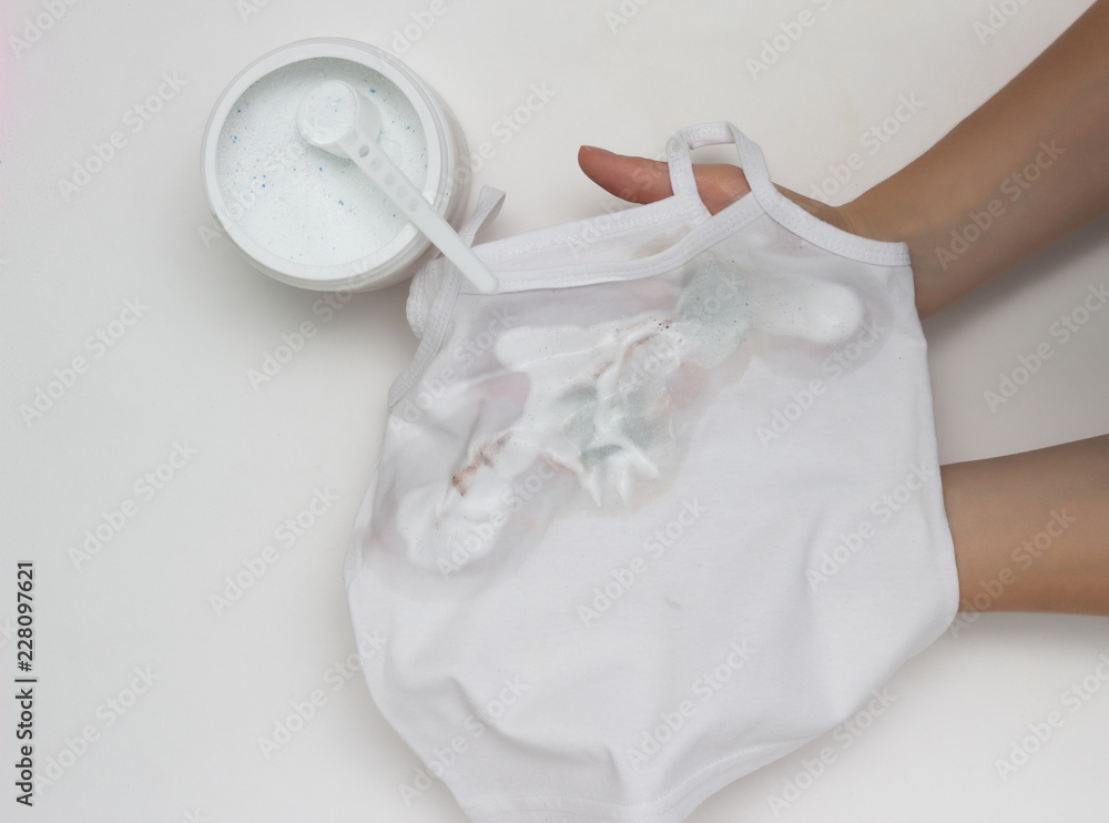 Girl puts on a dirty white T-shirt with stains, removes stains, hands ...