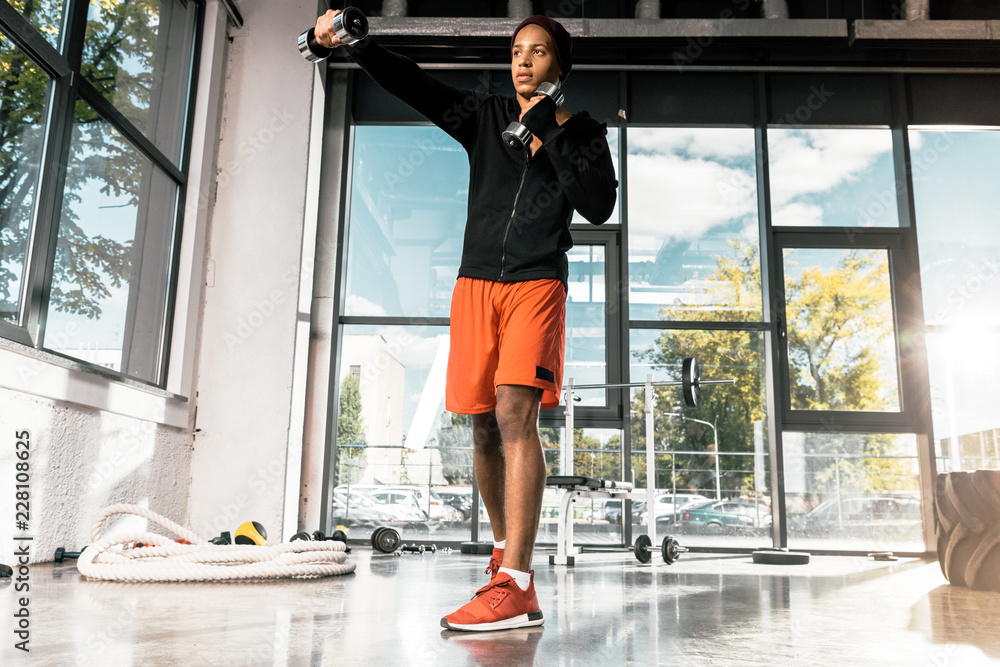 Selective focus of African American male boxer practicing with ...