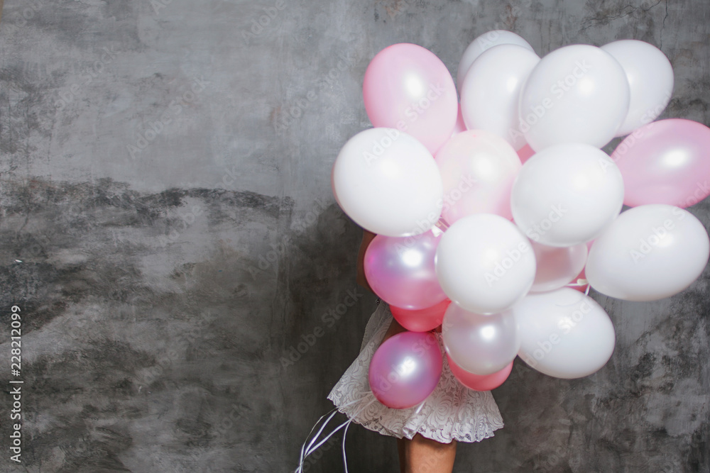 hide behind a large bunch of balloons. Girl and a lot of pink balloons ...