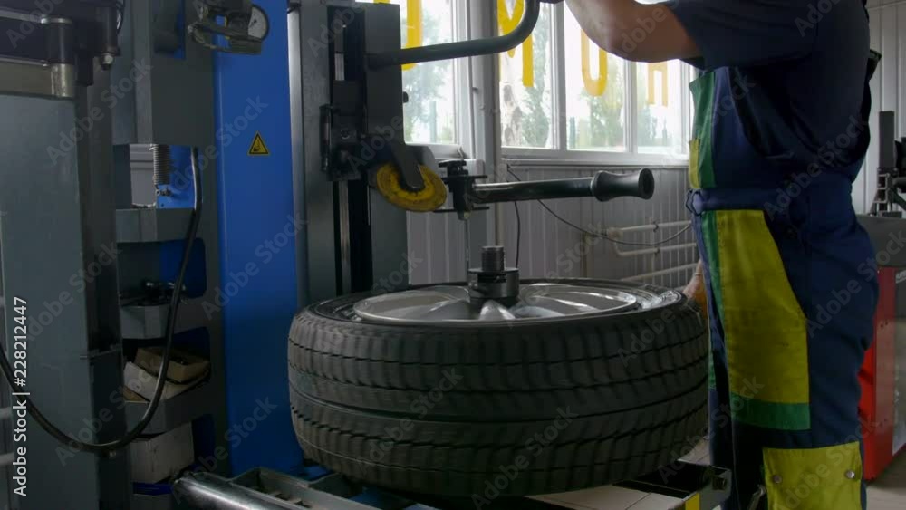 4k tyre fitter is servicing and checking and adjusting a wheel Stock ...