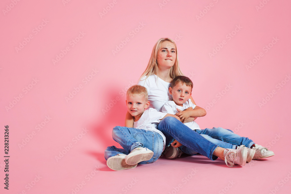 Beautiful blonde mom with two happy sons. Young woman and two baby boys ...