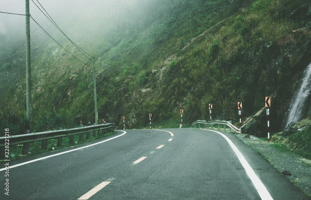 View of sky road over top of mountain with fog and green jungle after ...