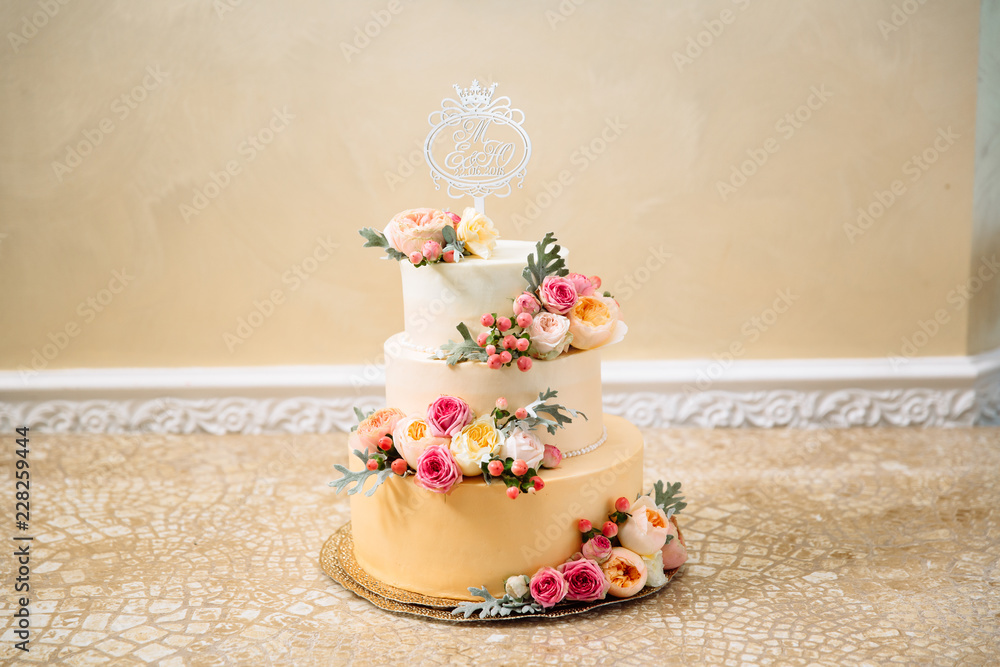 Golden wedding three-story cake. Close-up of a delicious dessert ...
