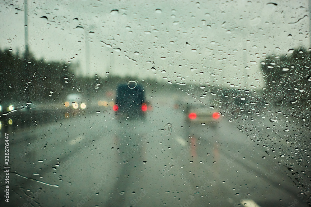blurred view of road traffic on a rainy day through the car window ...