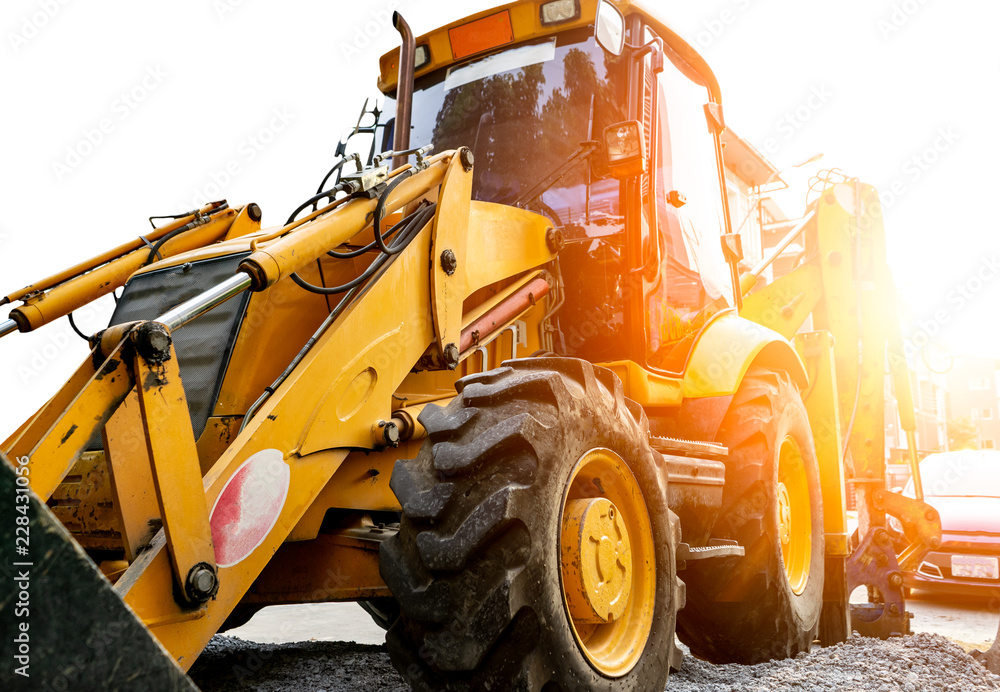 Yellow backhoe parking at construction site in the morning Stock Photo ...