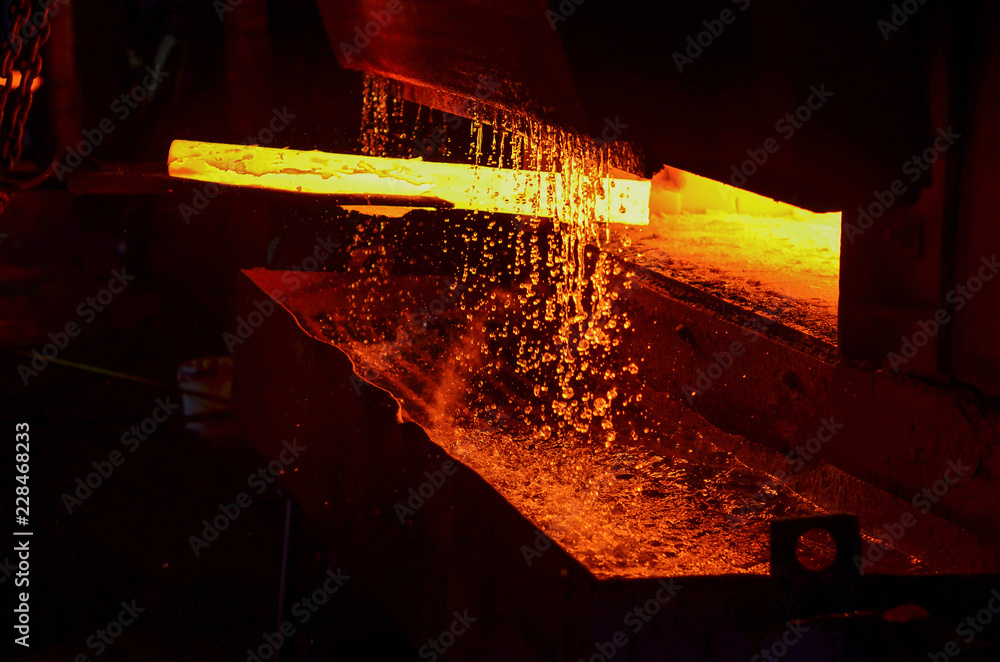 Hot iron in smeltery held by a worker. Iron melting recycling work ...