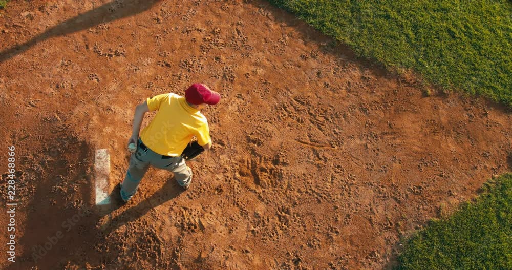 OVERHEAD CRANE Kid boy pitcher baseball player throws a ball from the ...