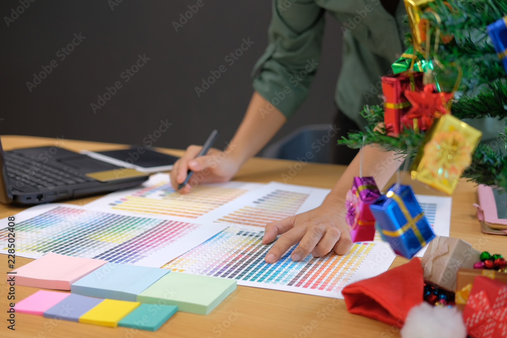 graphic interior designer choosing color from swatch sample catalogue ...