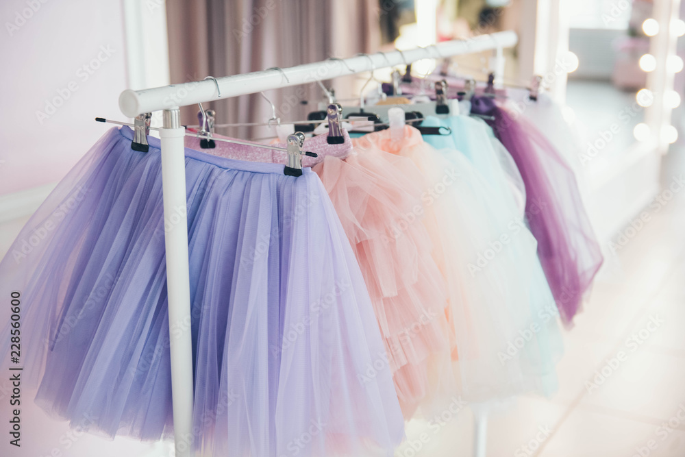 Clothing for a little girl on a clothes rack in a wardrobe. Fashion ...