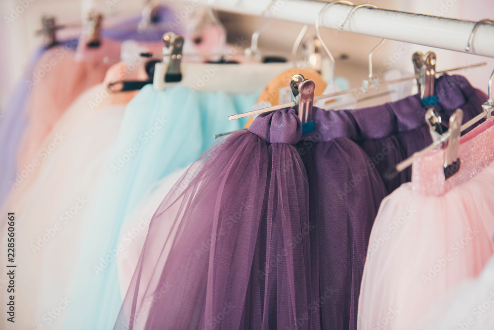 Clothing for a little girl on a clothes rack in a wardrobe. Fashion ...