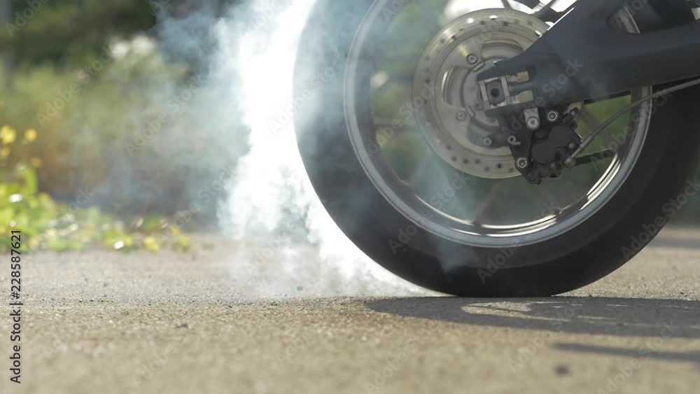Motorbike burnout, Biker on a motorcycle drifts in smoke, burns tire on ...