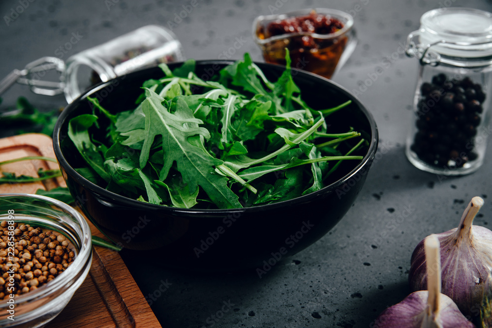 Rukola in a bowl. A view of food ingredients, rucola, garlic, dried ...