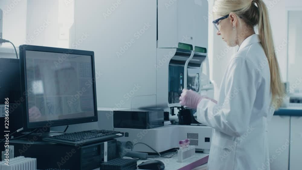 Female Research Scientist Puts Test Tube with Blood Sample into Medical ...