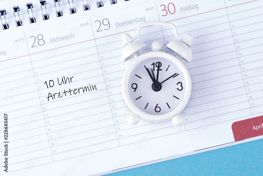 Kalender mit Termin beim Arzt und einem Wecker Stock-Foto | Adobe Stock