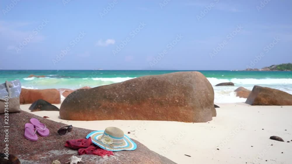 A slow linear(real time) dolly of beach props (sunhat, flip flops ...