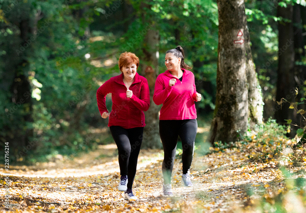 Mother and daughter wearing sportswear and running in forest Stock ...