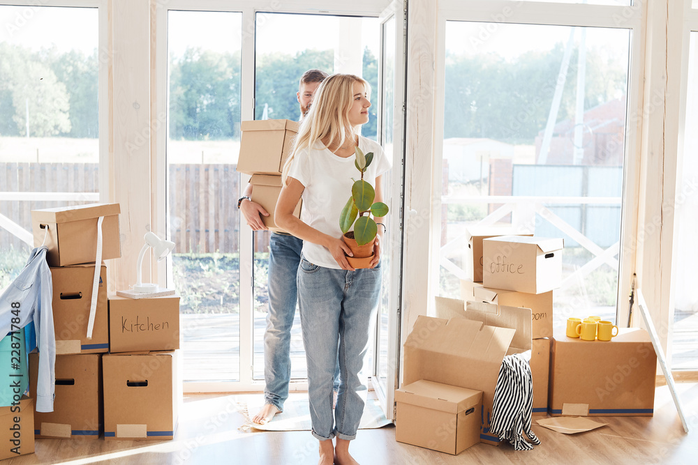 Happy young Couple Carrying Cardboard Boxes Into New Home On Moving Day ...
