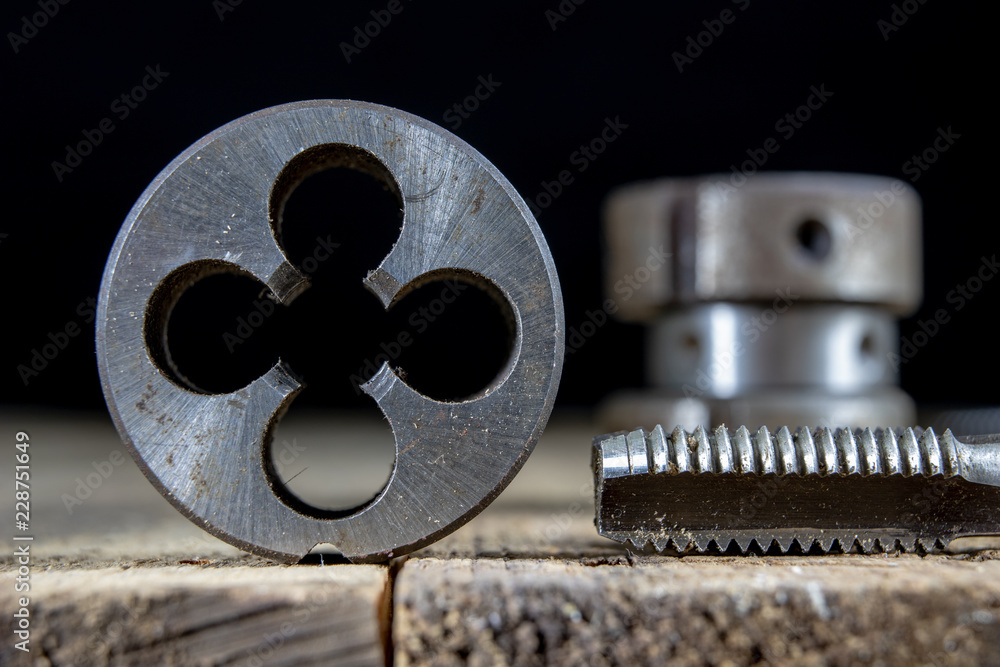 Metalwork tools on the workshop table. Threading dies and taps in an ...