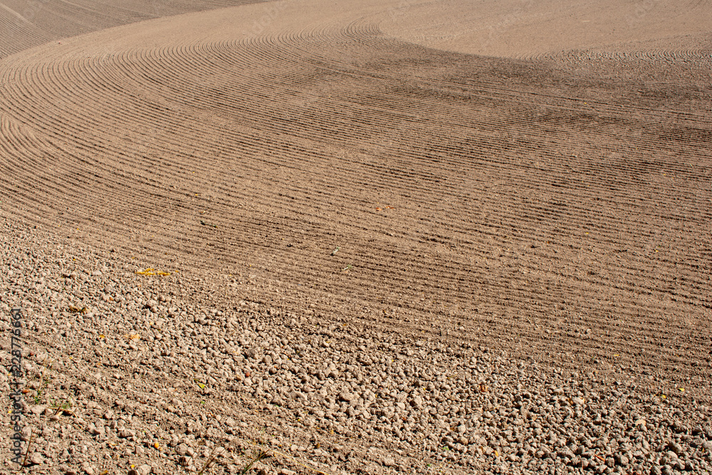 A close up view of newly tilled soil in a farm field prepared for ...