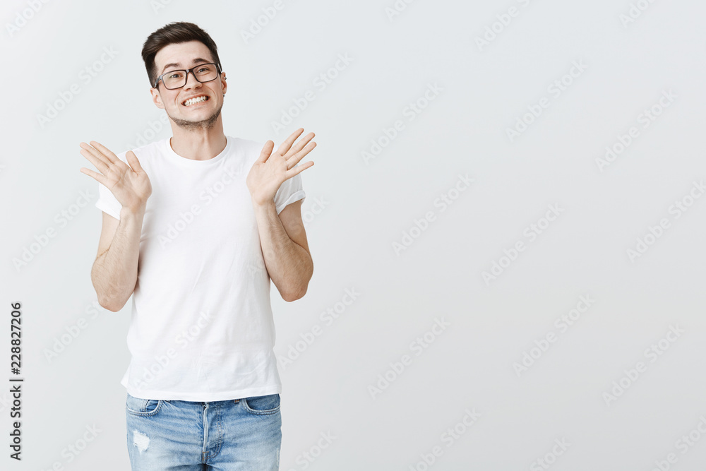 Apologizing handsome young male coworker in glasses raising hands near ...
