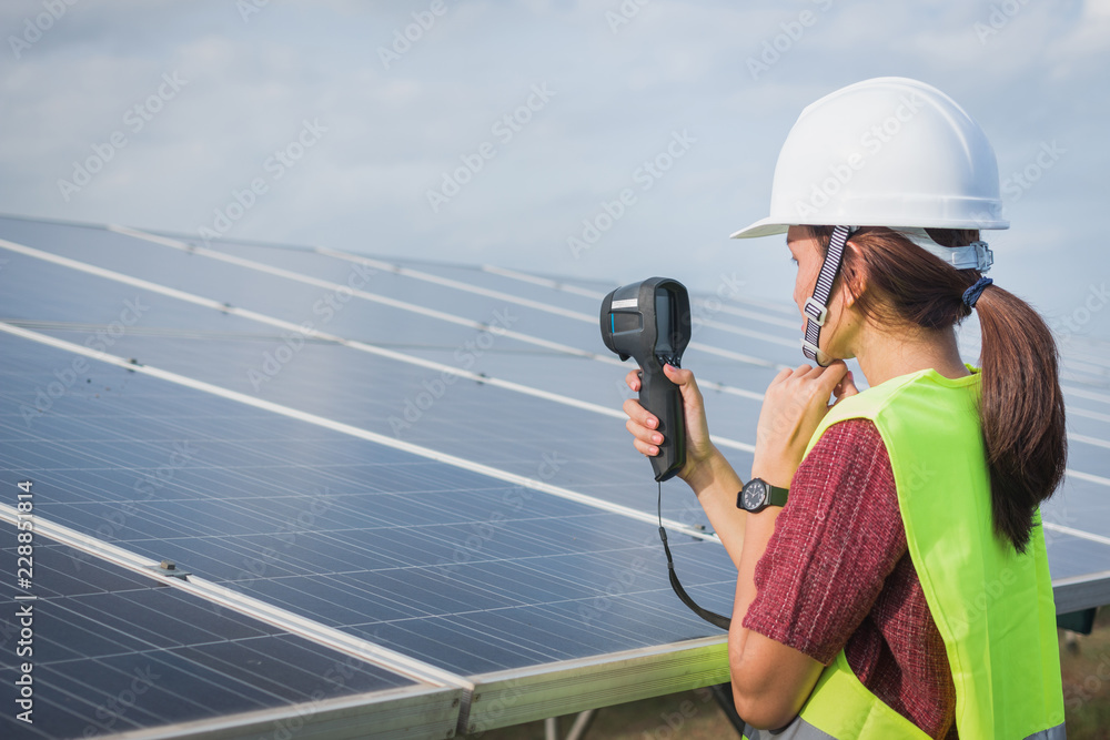 woman engineer checking heat of solar panel and using ir camera to scan ...