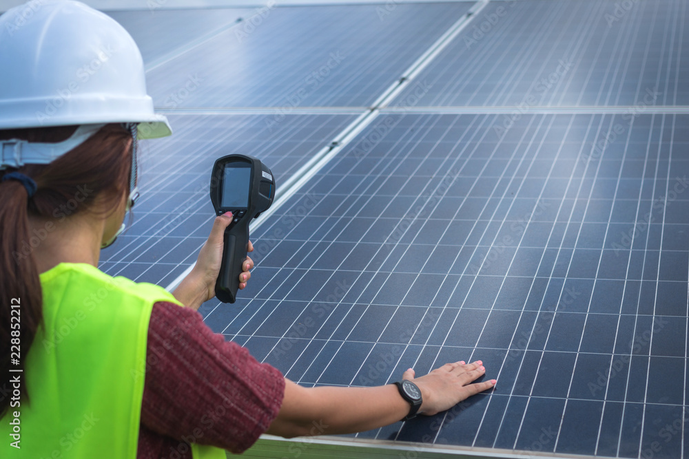 woman engineer checking heat of solar panel and using ir camera to scan ...