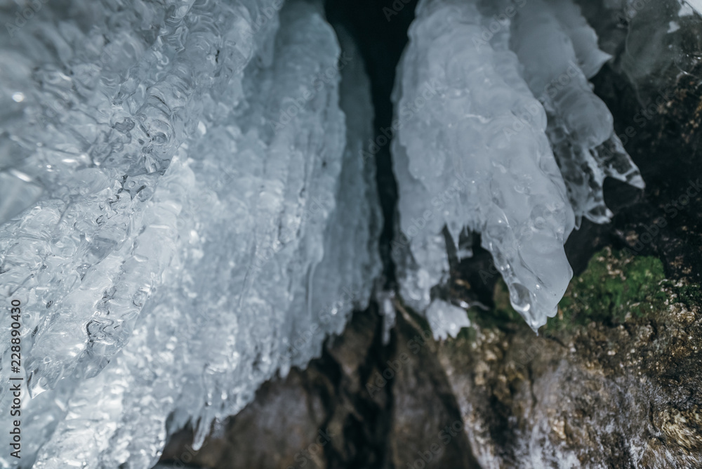 Winter Baikal. Olkhon Island. Ice grotto. Thick blue ice and icicles on ...