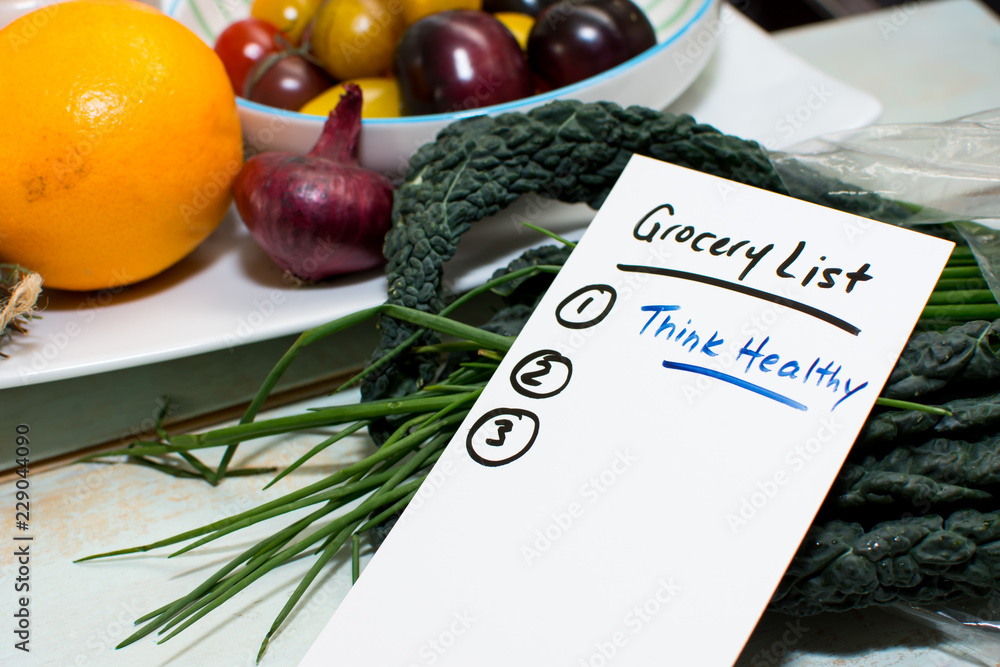 Think healthy grocery list on kitchen counter with superfoods kale and ...