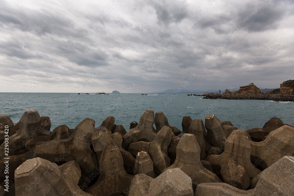 Tetrapod concrete blocks protecting a seawall along the coastline in ...