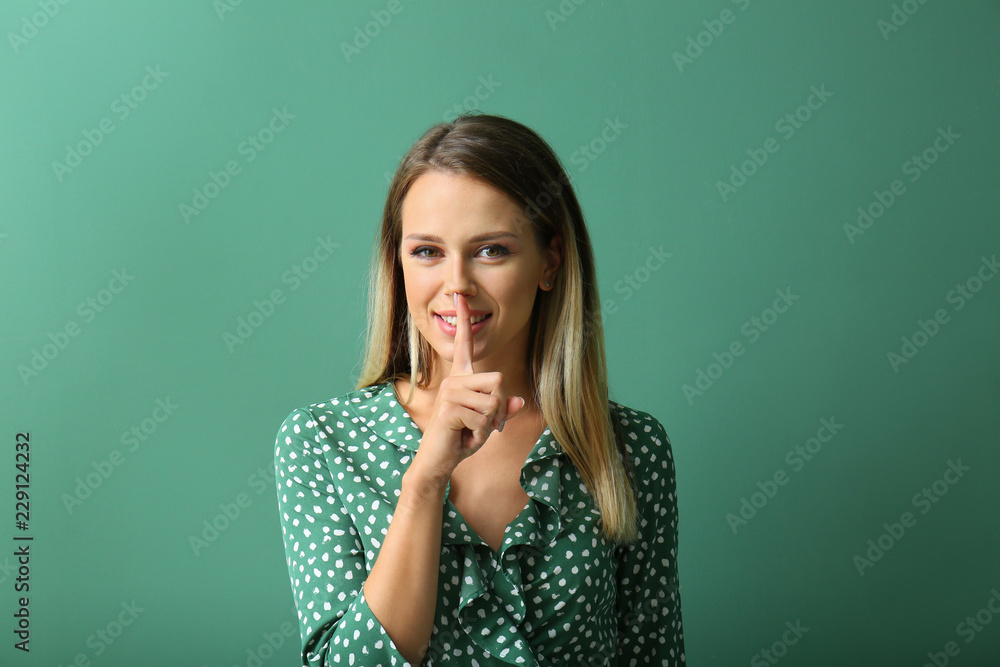Beautiful young woman showing silence gesture on color background Stock ...