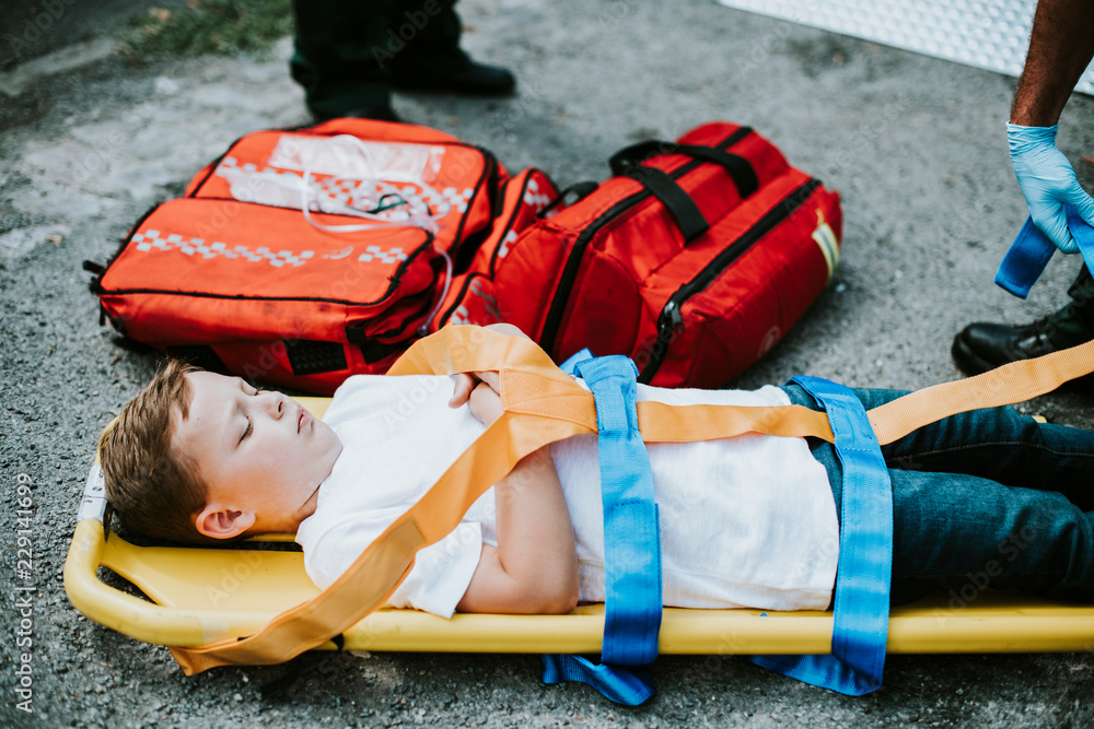 Young injured boy lying on an ambulance stretcher Stock Photo | Adobe Stock