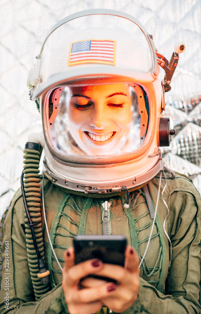 Beautiful female astronaut with mobile phone. Stock Photo | Adobe Stock