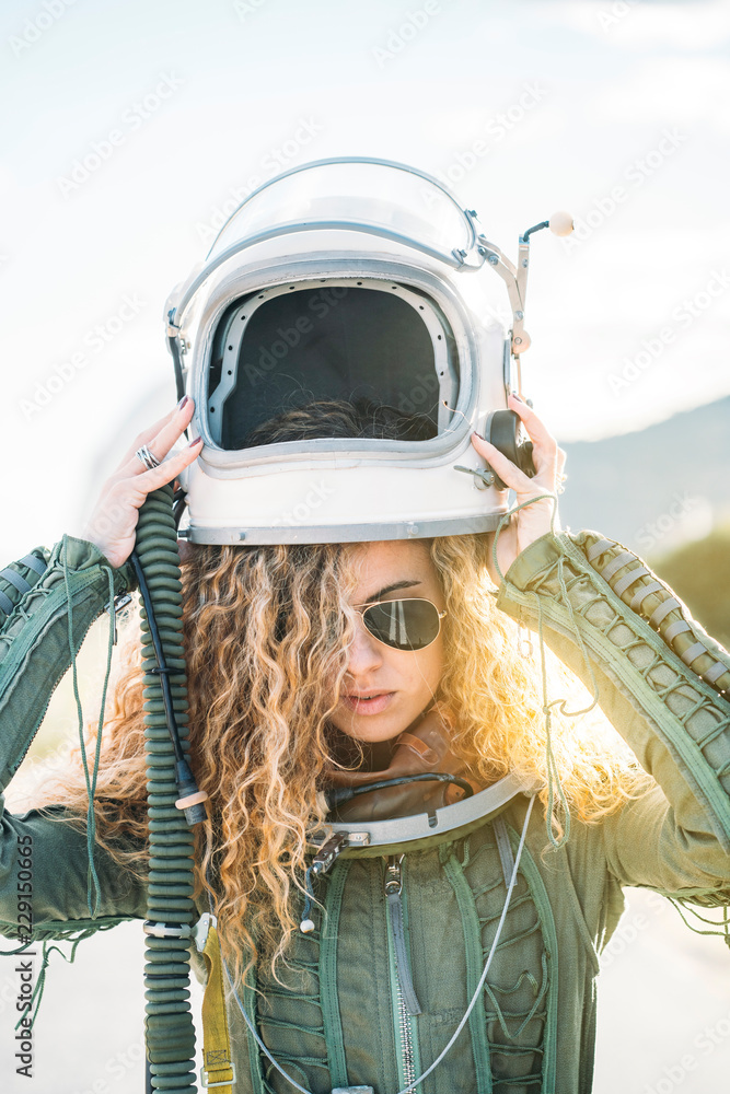 Beautiful woman putting the helmet dressed as an astronaut. Stock Photo ...