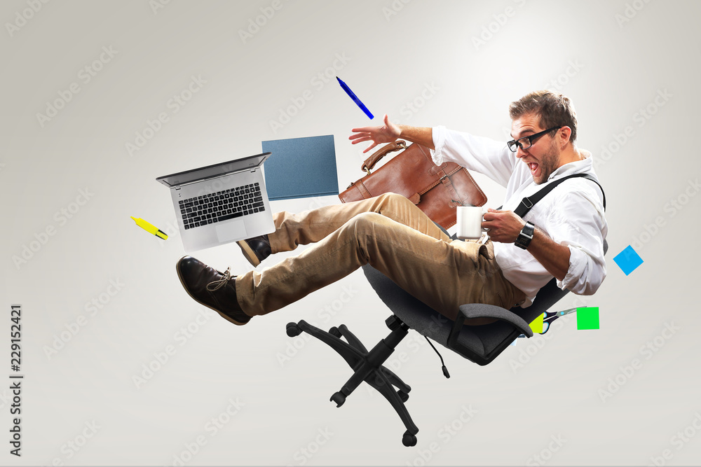 Young male employee falling from the chair Stock Photo | Adobe Stock