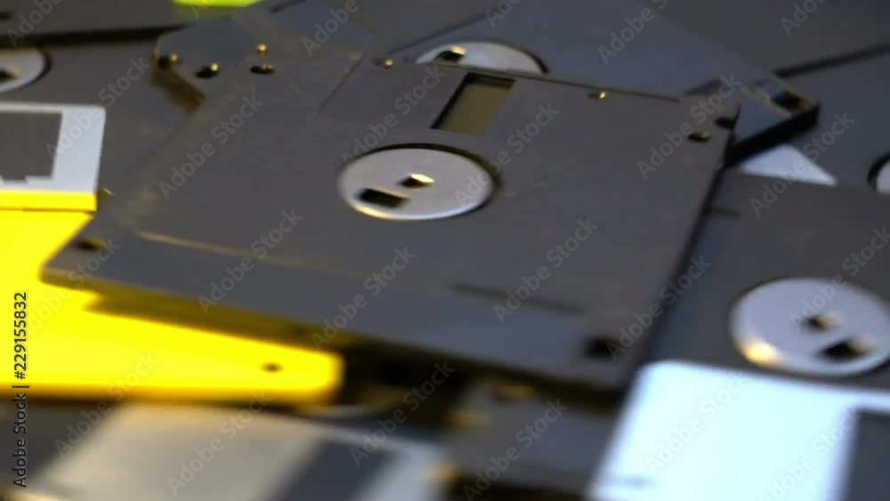 pile of old style data transfer floppy discs, rotating spinning ...