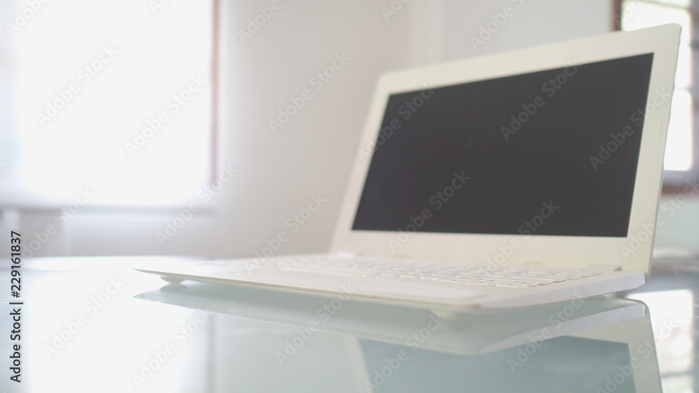 Place of work, laptop opened and blank screen on modern table with ...